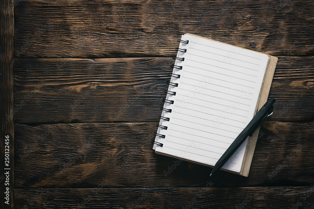 Blank notepad with empty paper sheets on the brown wooden table ...