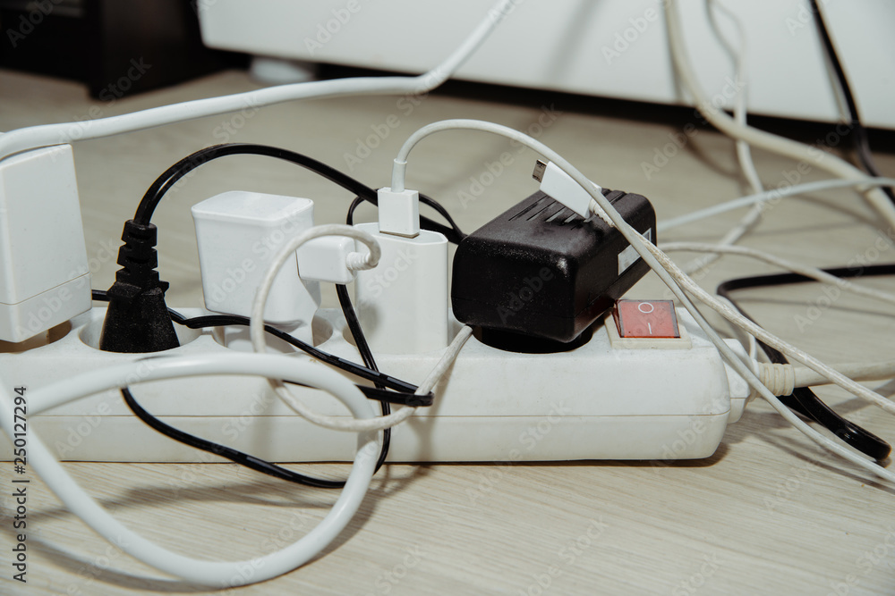 White electric power supply with plugs inserted. Electrical sockets ...