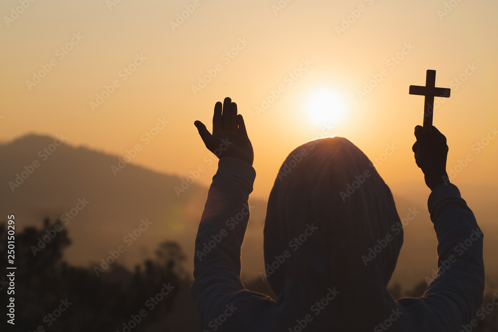Silhouette the cross in hands, religion symbol in light and landscape ...