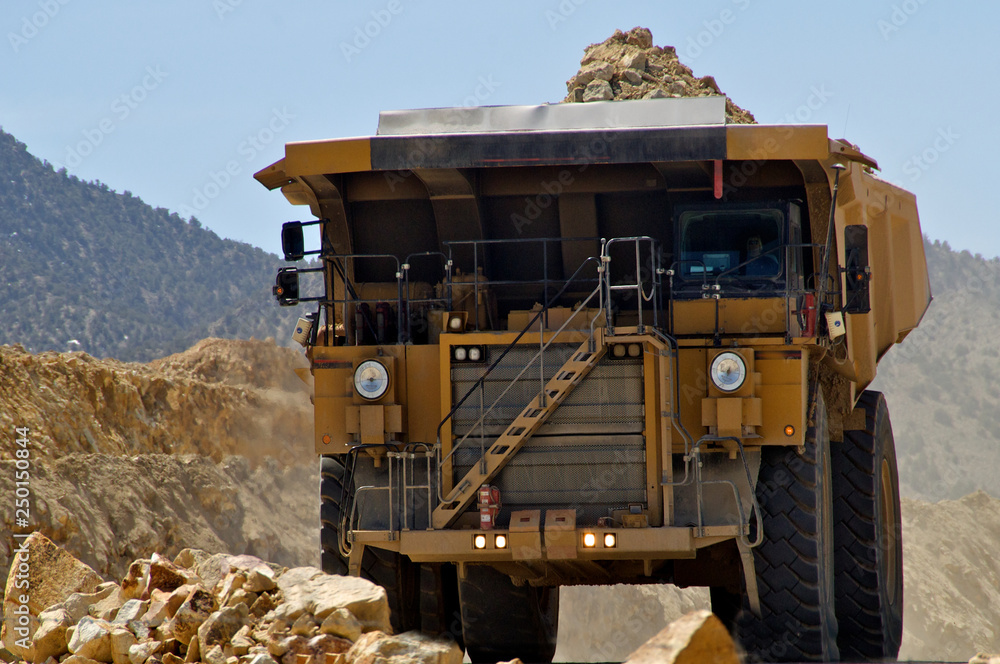 Gigantic Mining Haul Truck carrying 150 tons of ore exists large open ...