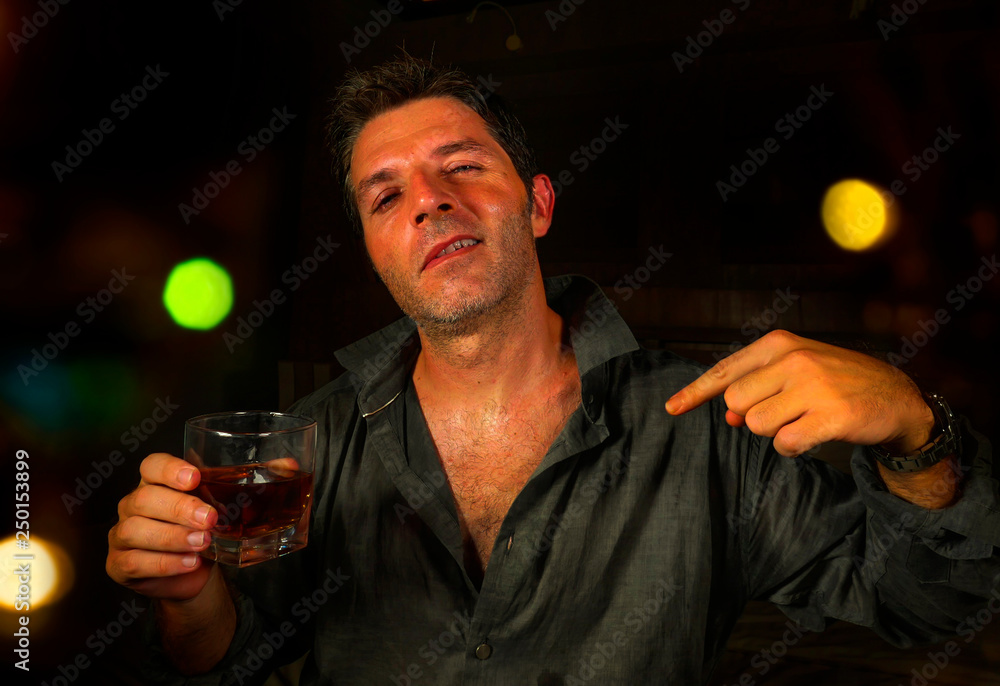 young messy and wasted man drunk at night club or bar drinking whiskey ...