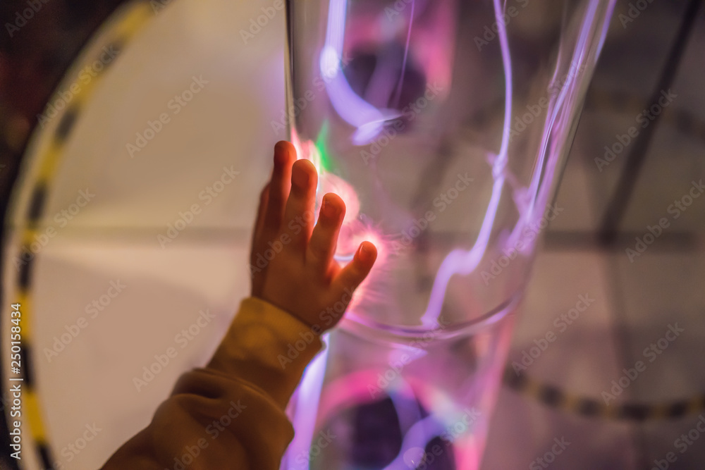 Hand of a boytauching the tube with glowing gas. inert gas light ...