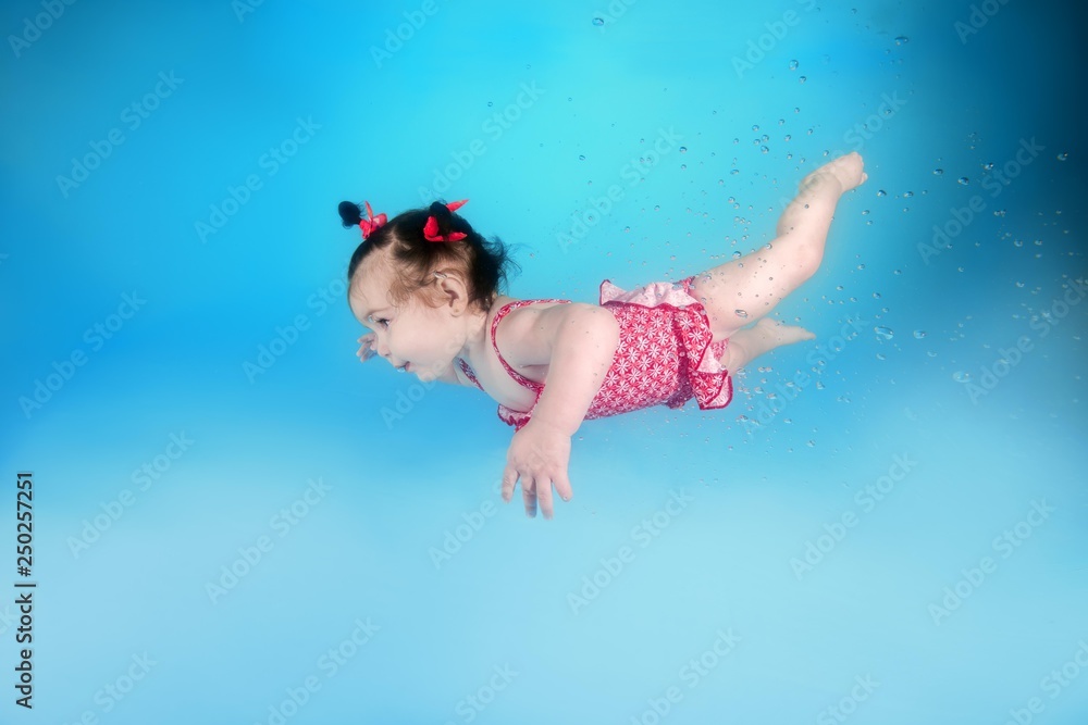 Little girl In a pink swimsuit diving in the swimming pool, Ukraine ...