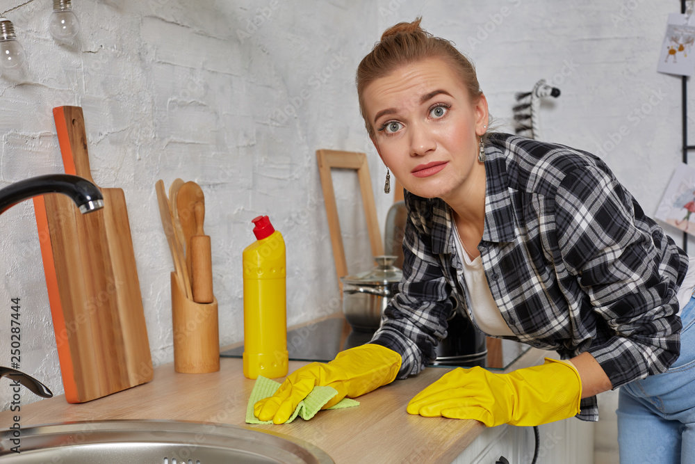 Young woman washing manually, by hand, wearing yellow cleaning rubber ...