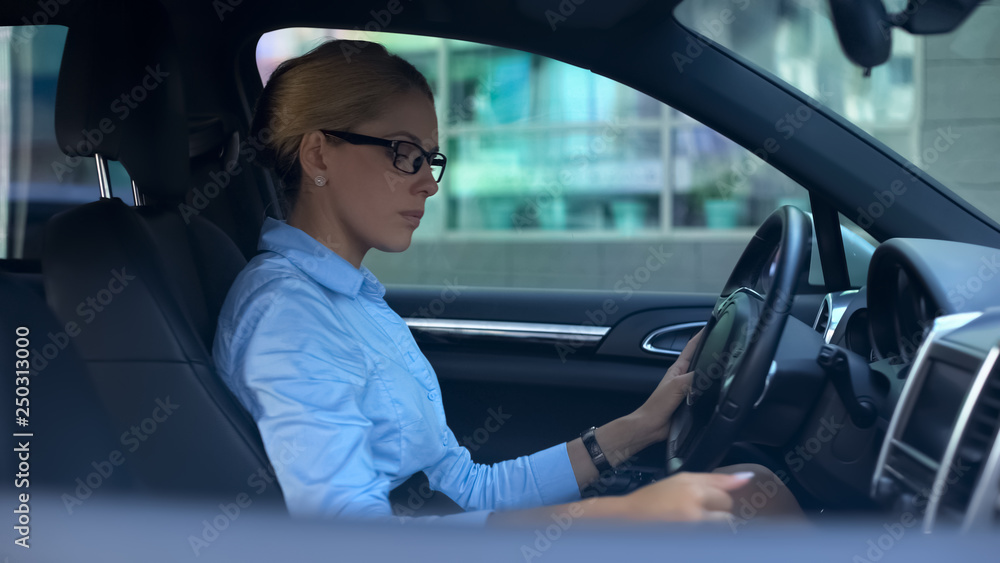 Confident woman shifting gear trying to run car, test-drive of luxury ...