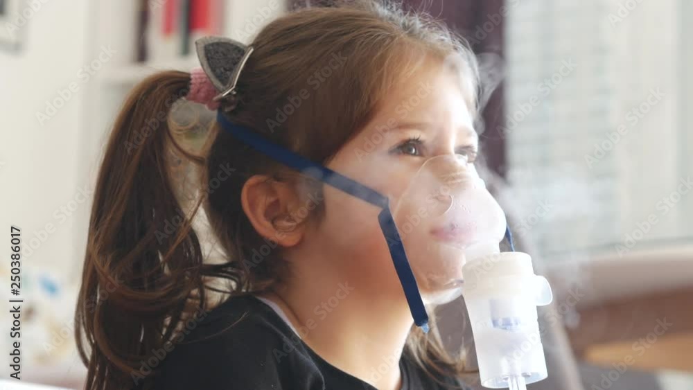 Cute caucasian girl in casual clothes using oxygen mask and making ...