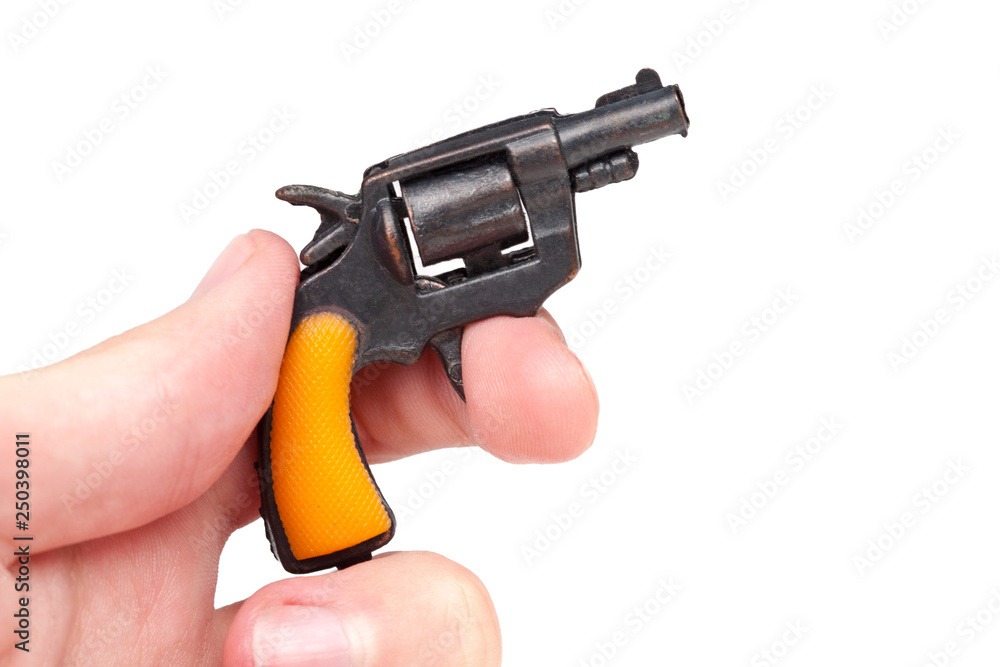 Hand holding small tiny gun prop pulling the trigger isolated on white ...
