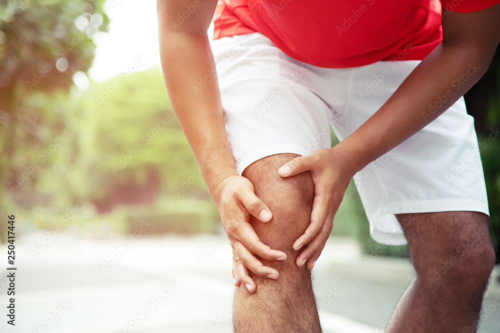 Runner touching painful twisted or broken ankle. Athlete runner ...