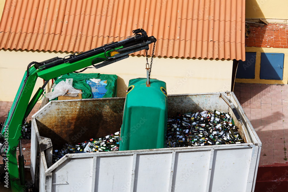 Disposal truck collects recycable mixed glass bottles from container ...