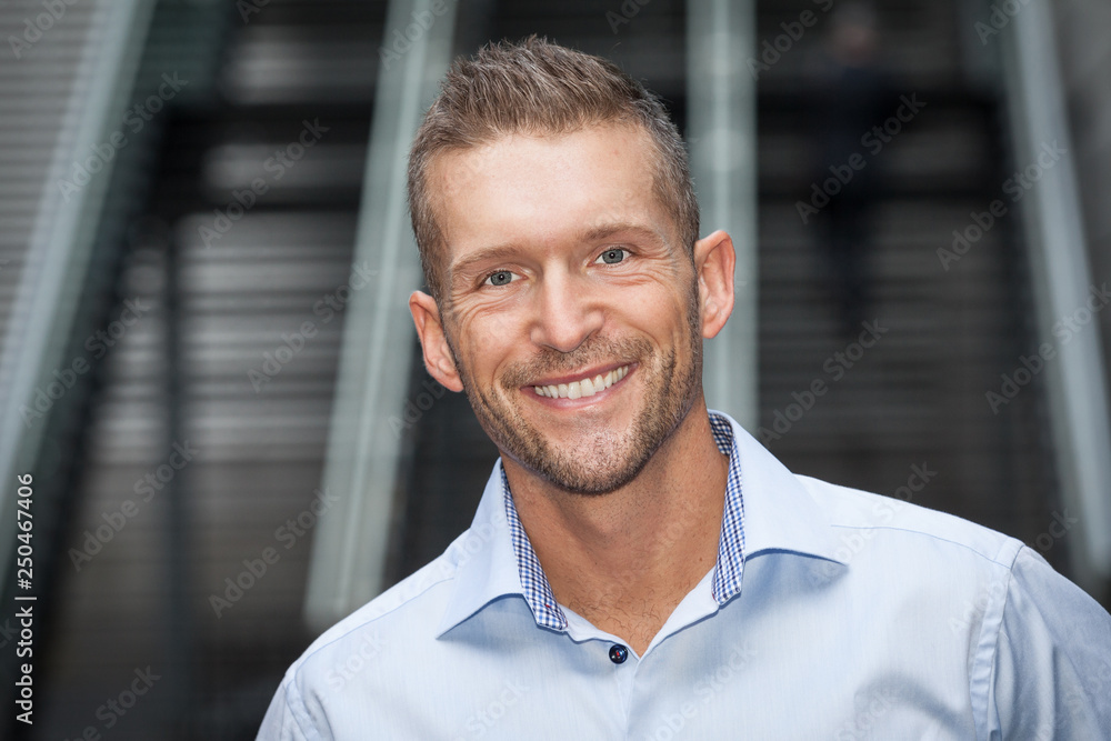 Handsome man with short beard smiling on a stairs background Stock ...