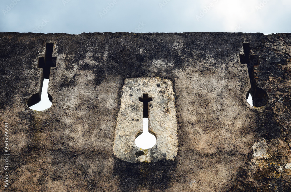 Poster ancient medieval cross shaped arrow slit on the wall of an old ...