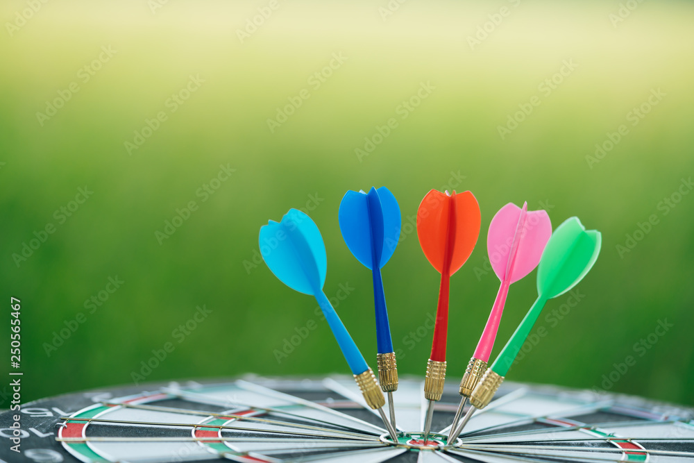 Foto de Five multi color dart arrows hitting in the target center of ...