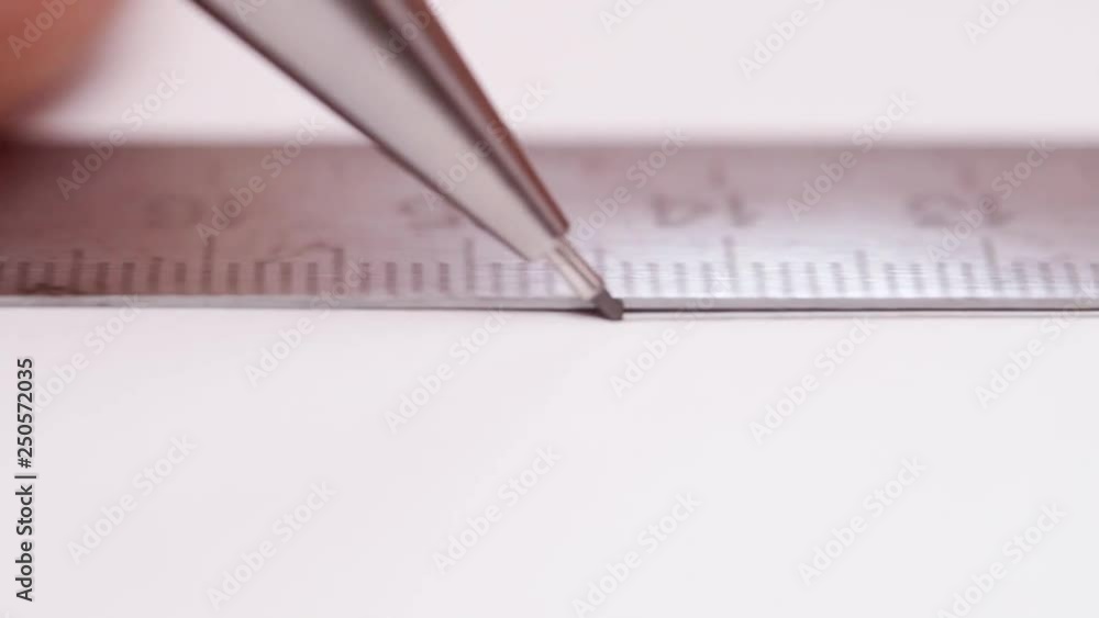 Calligraphist drawing a line with brush pen and iron ruler. Preparing ...