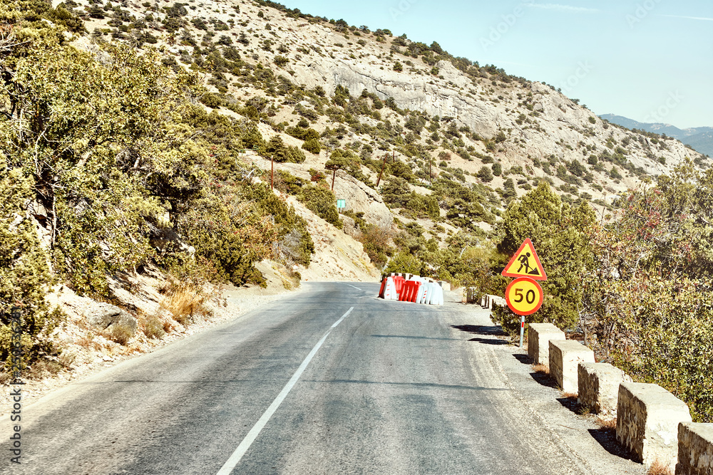 old dangerous road in mountains with vintage road work ahead warning ...