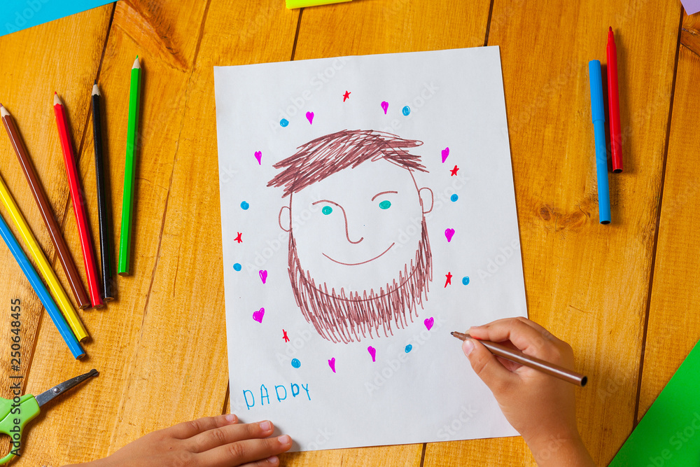 Child draws a portrait of his dad on father's day. The little boy did ...