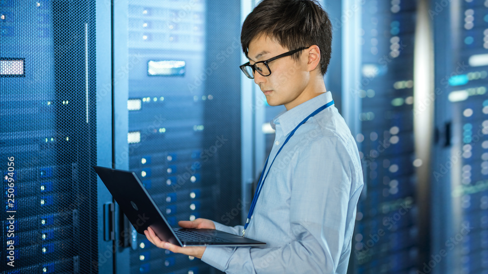 In the Modern Data Center: IT Engineer Standing Beside Server Rack ...