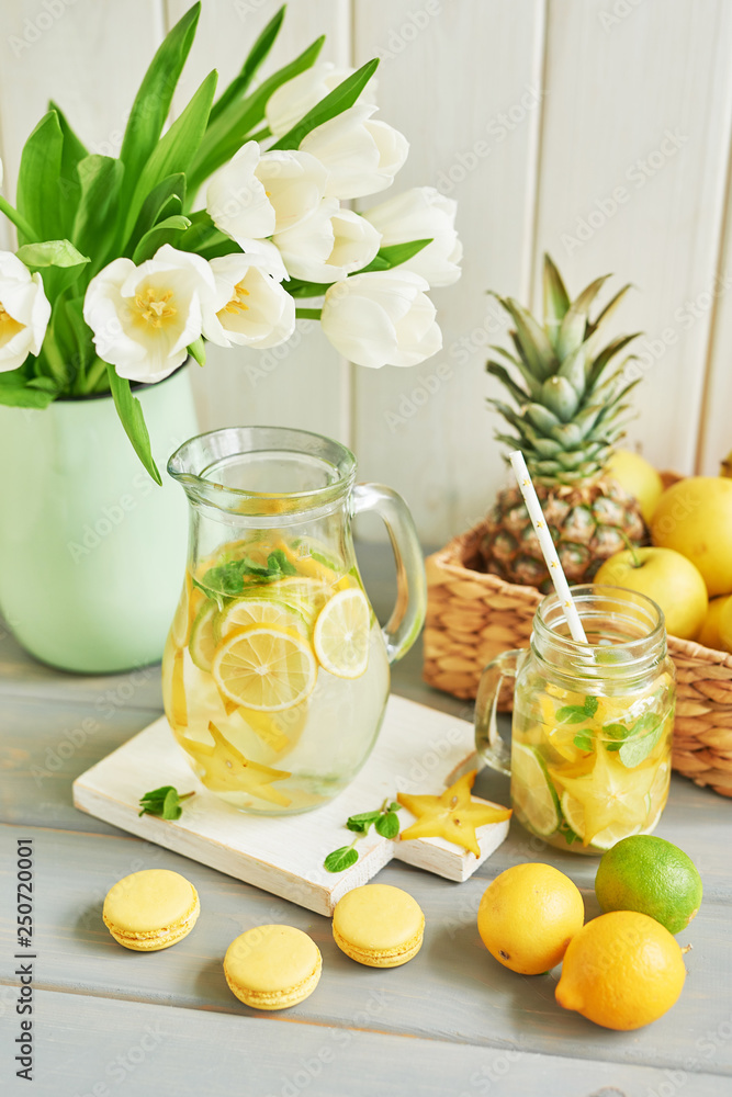 Lemonade and flowers tulips on table. Mason jar glass of lemonade with ...