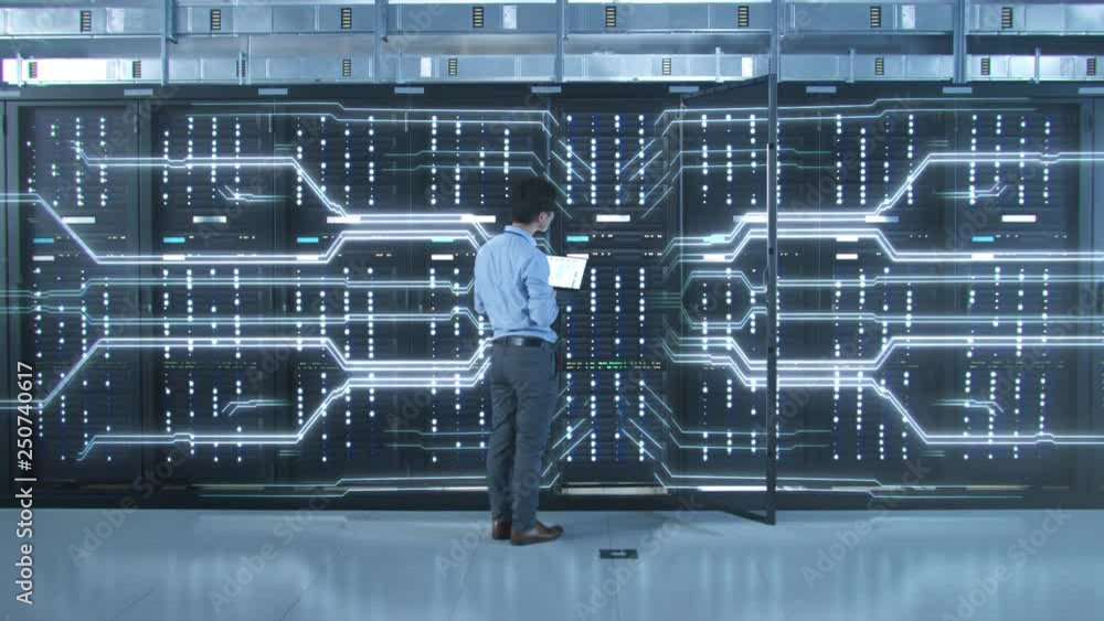 IT Specialist Standing In front of Server Racks with Laptop, He ...
