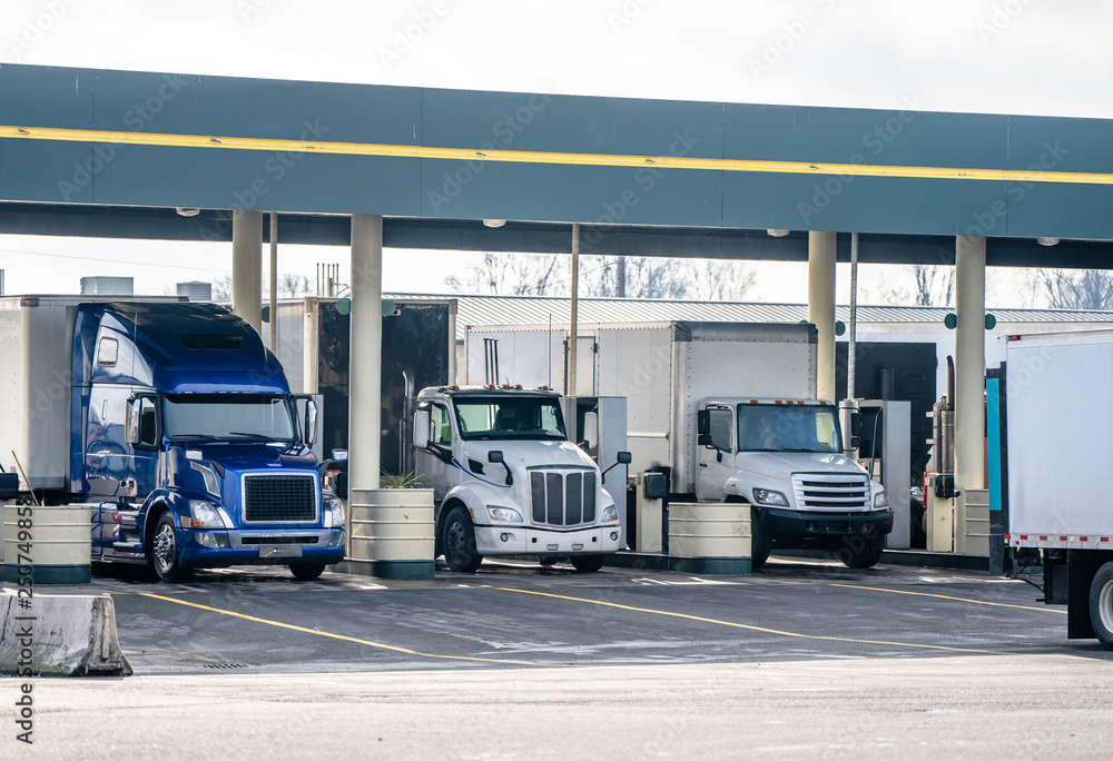 Big rigs small rigs and middle rigs semi trucks refuel at the gas ...