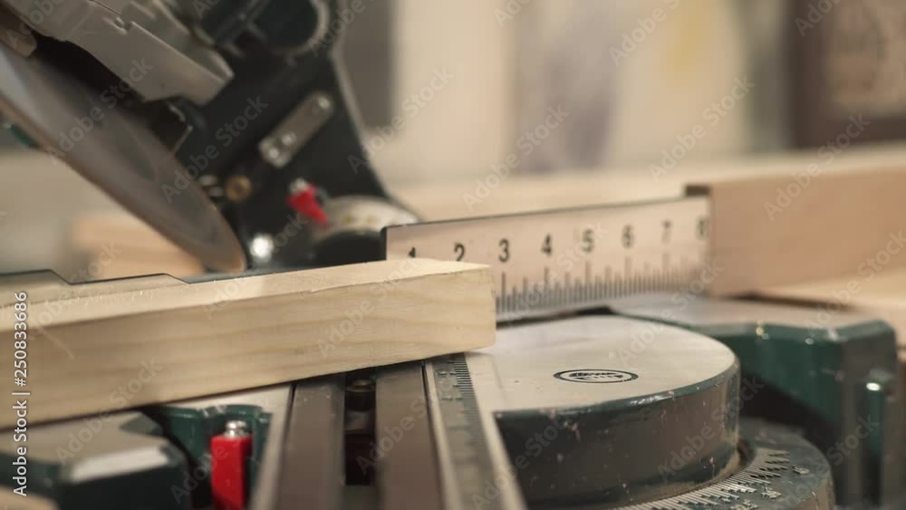 Vidéo Stock A front view of a miter saw cutting a work piece at a ...