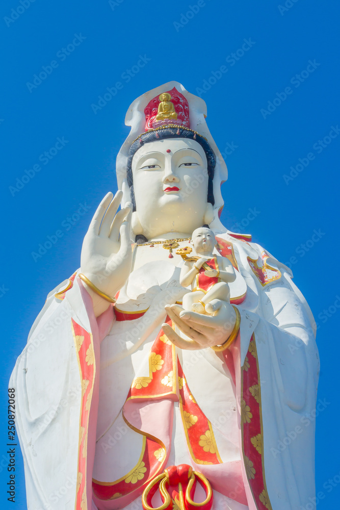 Giant white Guanyin statue with blue sky background. Guanyin or Guan ...