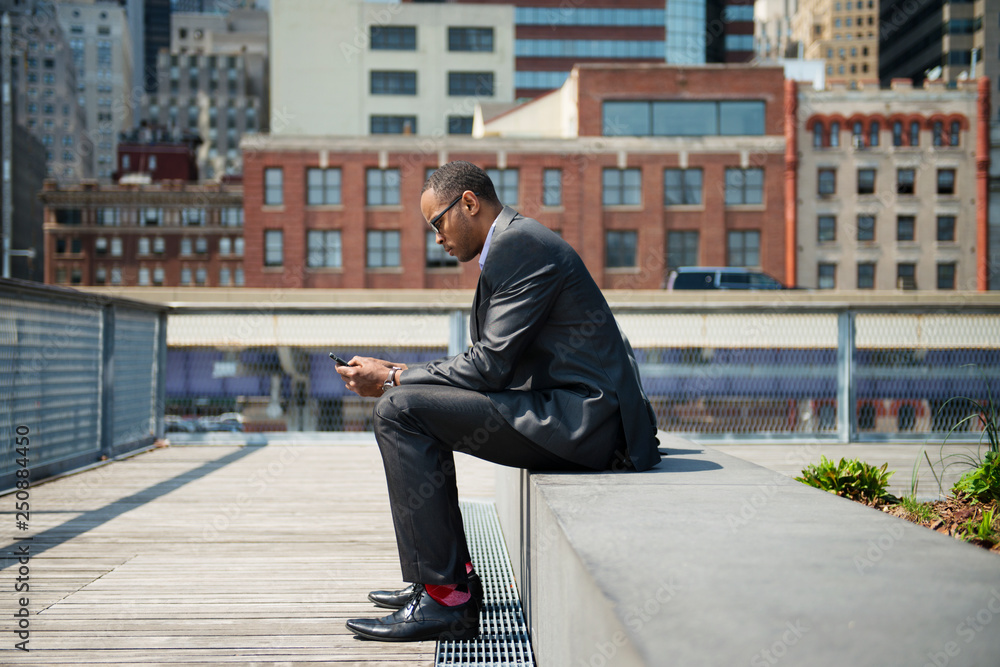 Man wearing suit, sitting on ledge, , Stock Photo | Adobe Stock