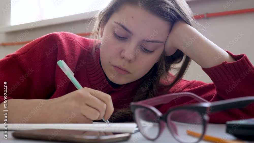 Student making notes. Female writing down notes. Listening lecture with ...