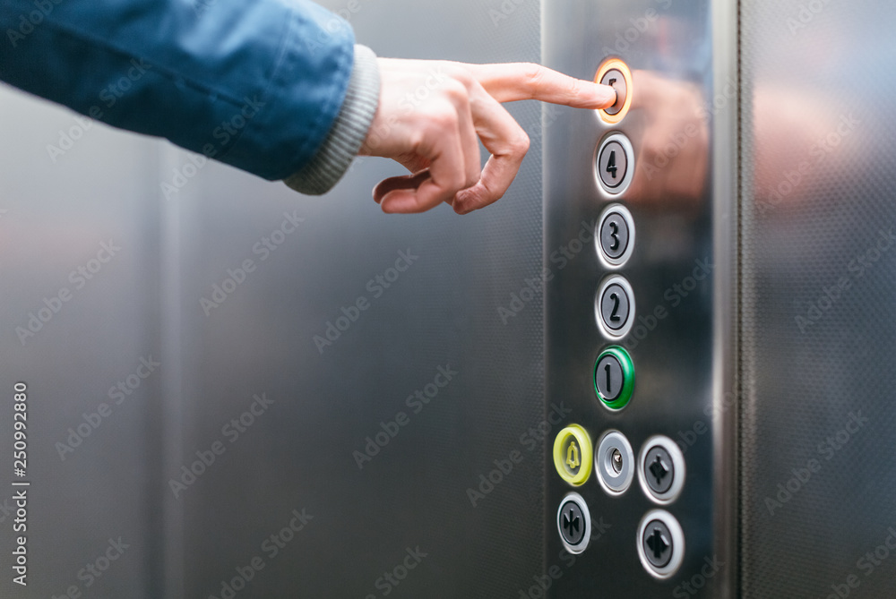 Forefinger of adult man pressing the fifth floor button in the elevator ...