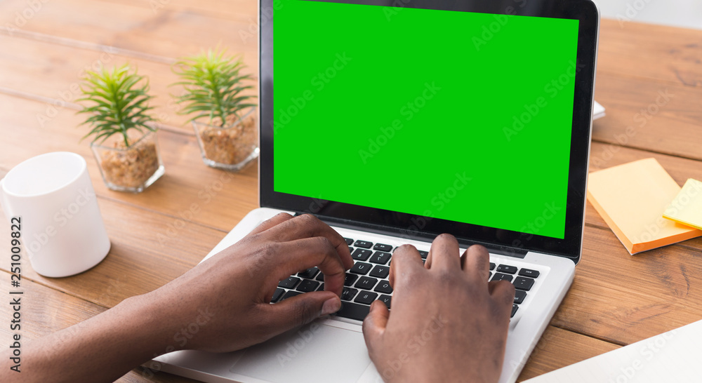 Millennial man working on laptop with blank green screen Stock Photo ...