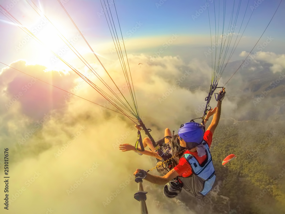 Paragliding in the sky. Paraglider tandem flying over the sea with blue ...