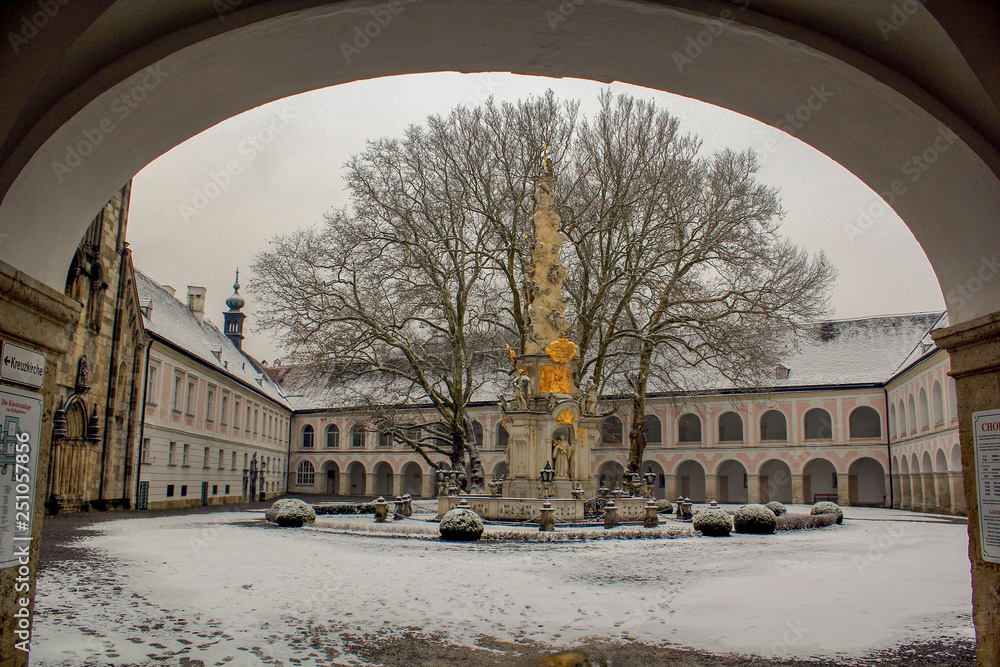 View from the arch to the snow-covered courtyard fenced on three sides ...