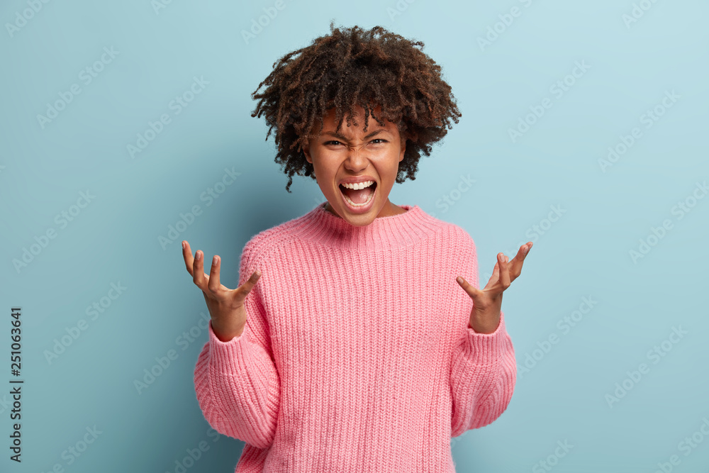 Angry annoyed lady with crisp hair, gestures and yells with negative ...