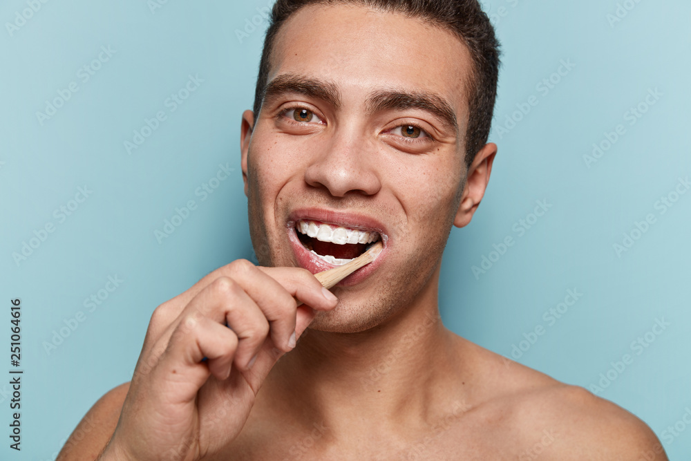 Smiling young man with healthy teeth, holds toothbrush, cares of dental ...