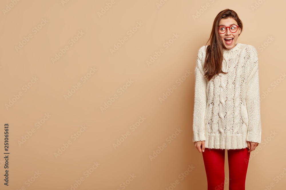 Pleased woman with cheerful expression, looks aside, opens mouth with ...