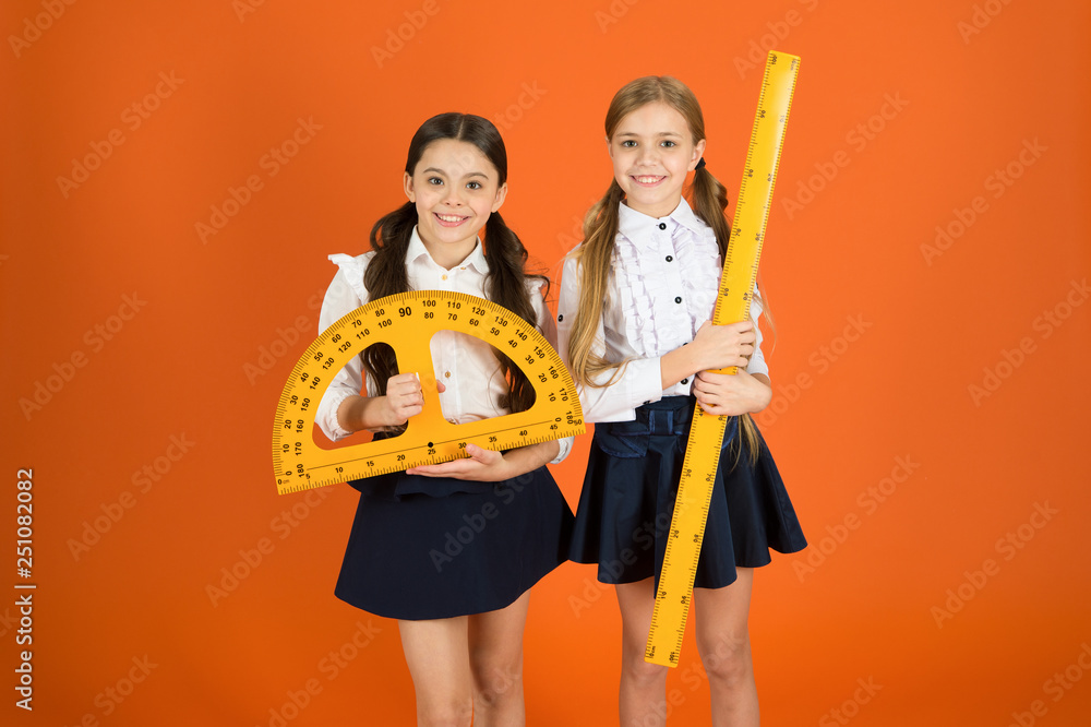 Having a private lesson. Cute schoolgirls holding protractor and ruler ...
