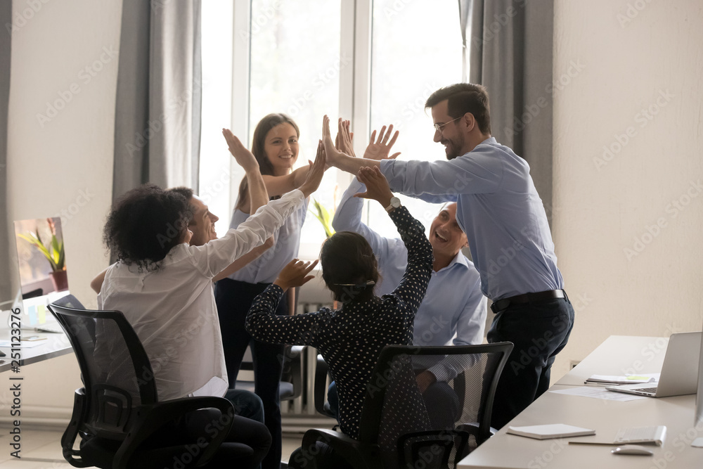 Diverse group of people giving high five in office Stock Photo | Adobe ...