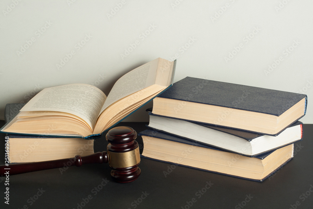 Law concept. Books with wooden judges gavel on table in a courtroom or ...
