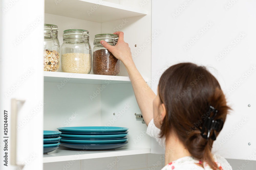 Women picking an item from storage hutch. Smart kitchen organization ...