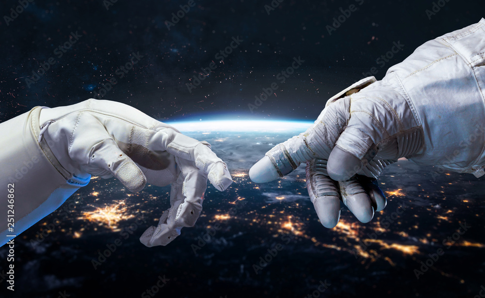 Astronaut and robot hands in the space. Earth planet on the background ...