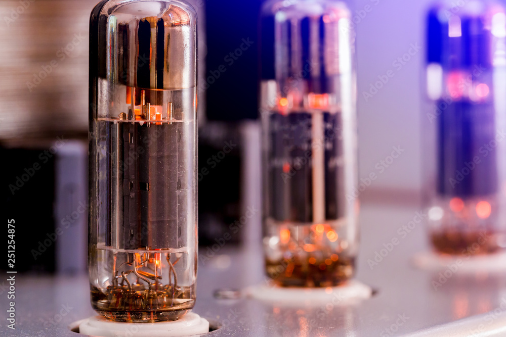Old-fashioned electronic device amplifier with glowing bulb diode lamp ...
