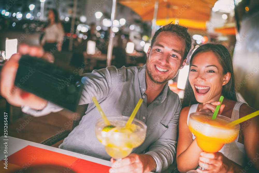 Fun date night out young people taking selfie of themselves drinking ...