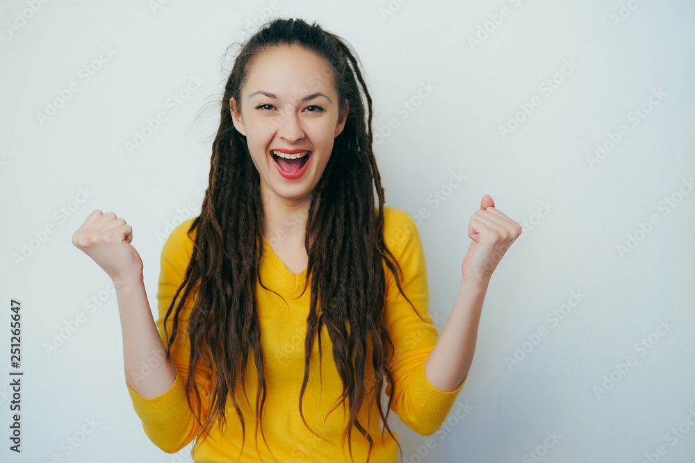 Excited overjoyed Beautiful girl with dreadlocks and in a yellow bright ...