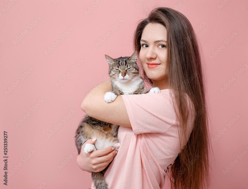 young attractive woman hugging cat in hands, pink background Stock ...