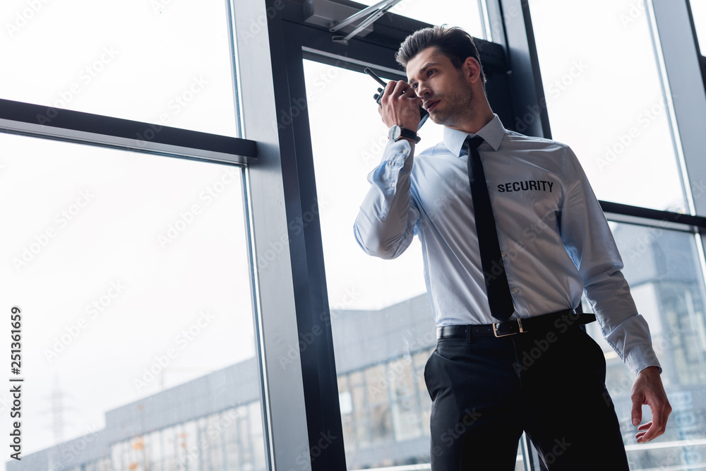 handsome guard in suit talking on walkie-talkie Stock Photo | Adobe Stock