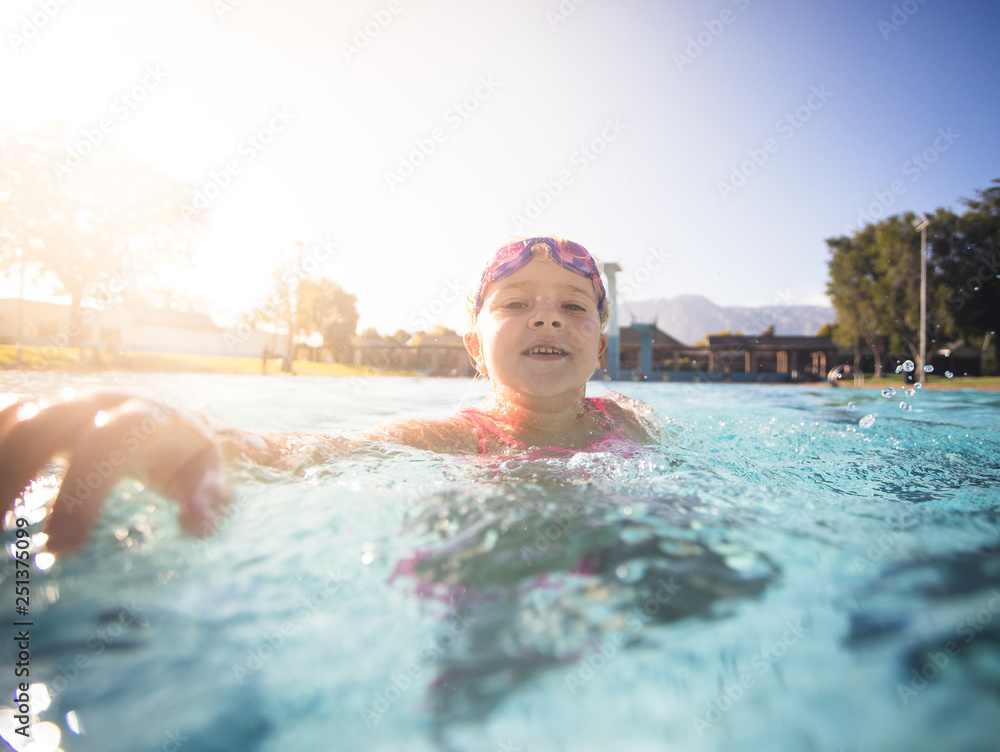 Wide angle underwater photo of a toddler girl swimming in a big ...