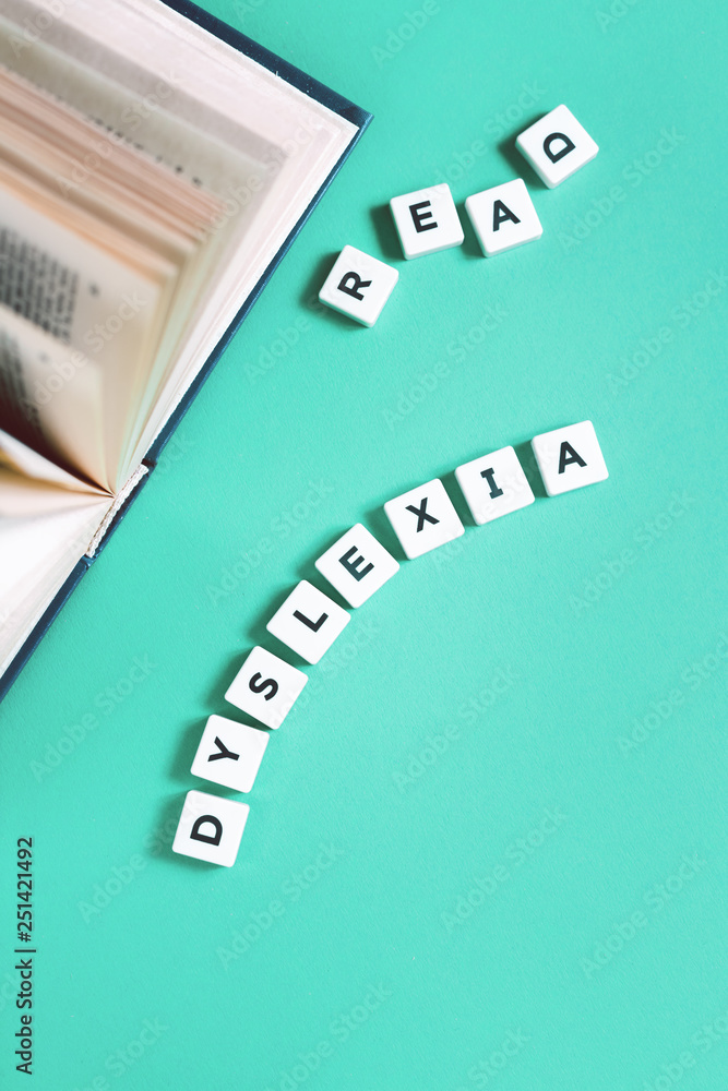 Dyslexia and read words with an open book on mint background, reading ...
