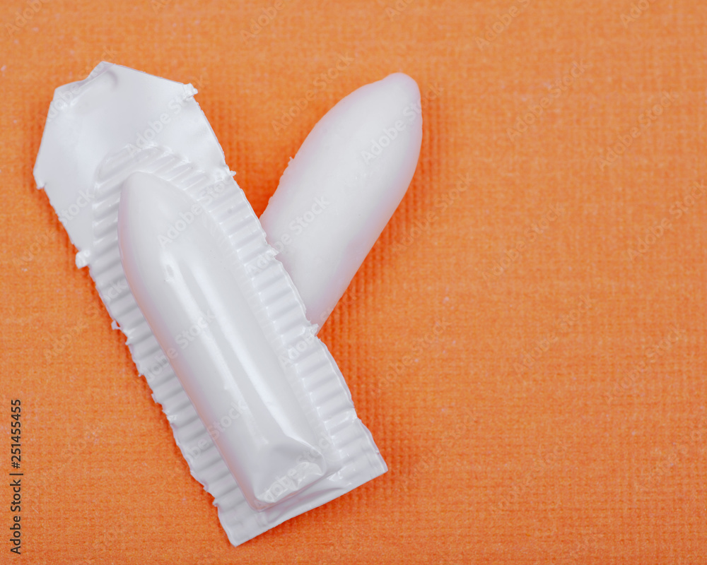 Medication in disposable plastic suppository moulds on orange ...
