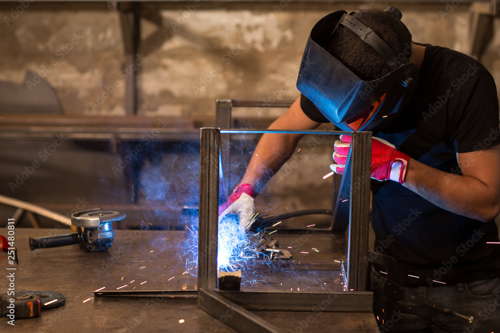 Strong muscular male welder working hard with welding machine. Stock ...
