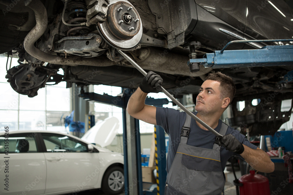 Male Mechanic Under Car