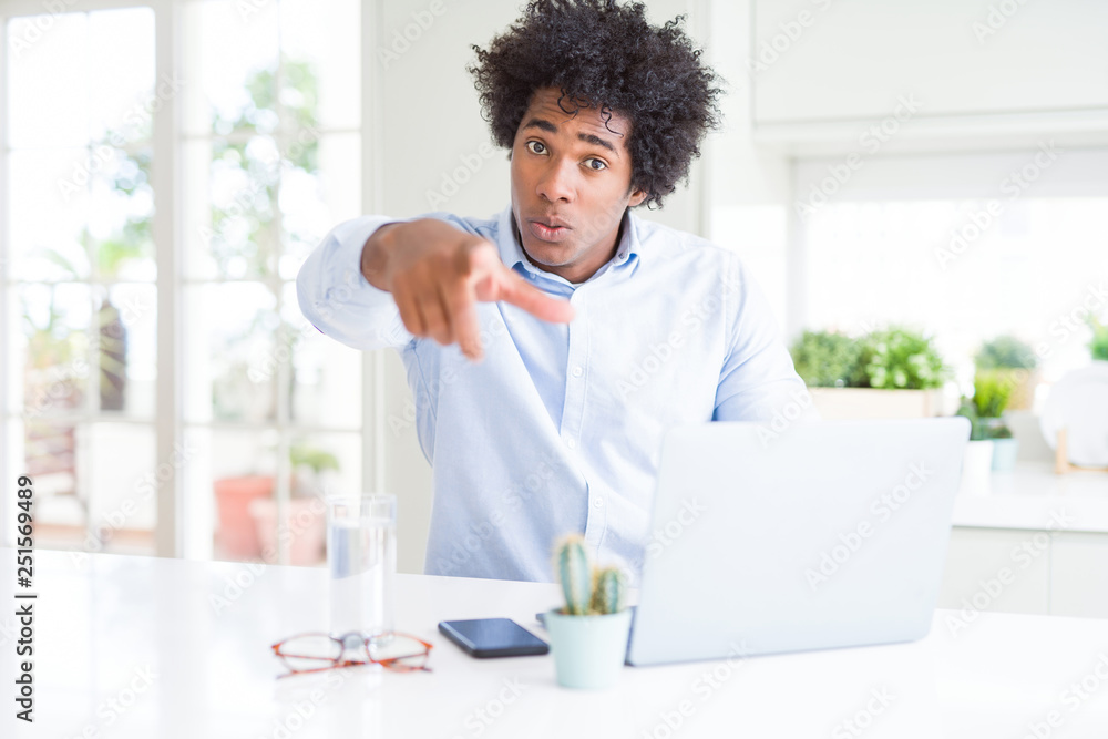 African American business man working using laptop pointing with finger ...